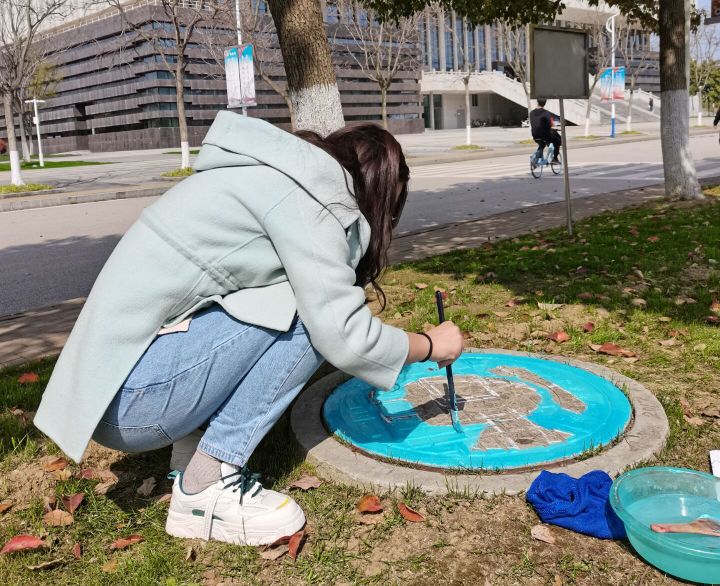 美化校园井盖 传承雷锋精神